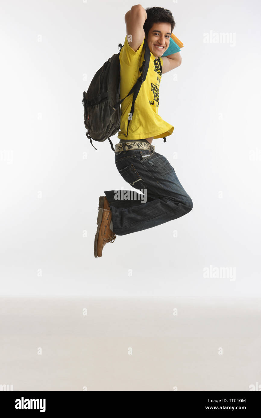 College student jumping and smiling Stock Photo - Alamy