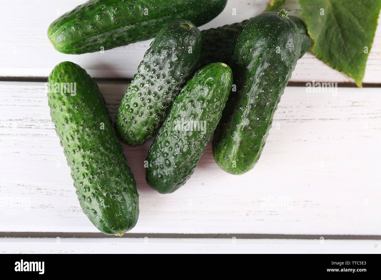 Cucumbers on light wooden background Stock Photo - Alamy