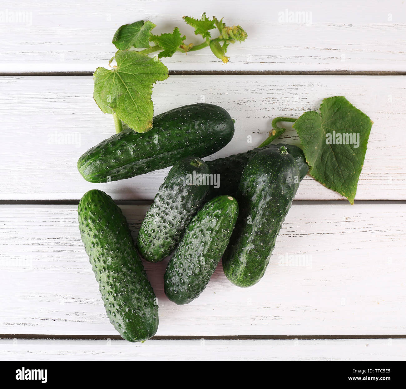 Cucumbers on light wooden background Stock Photo - Alamy