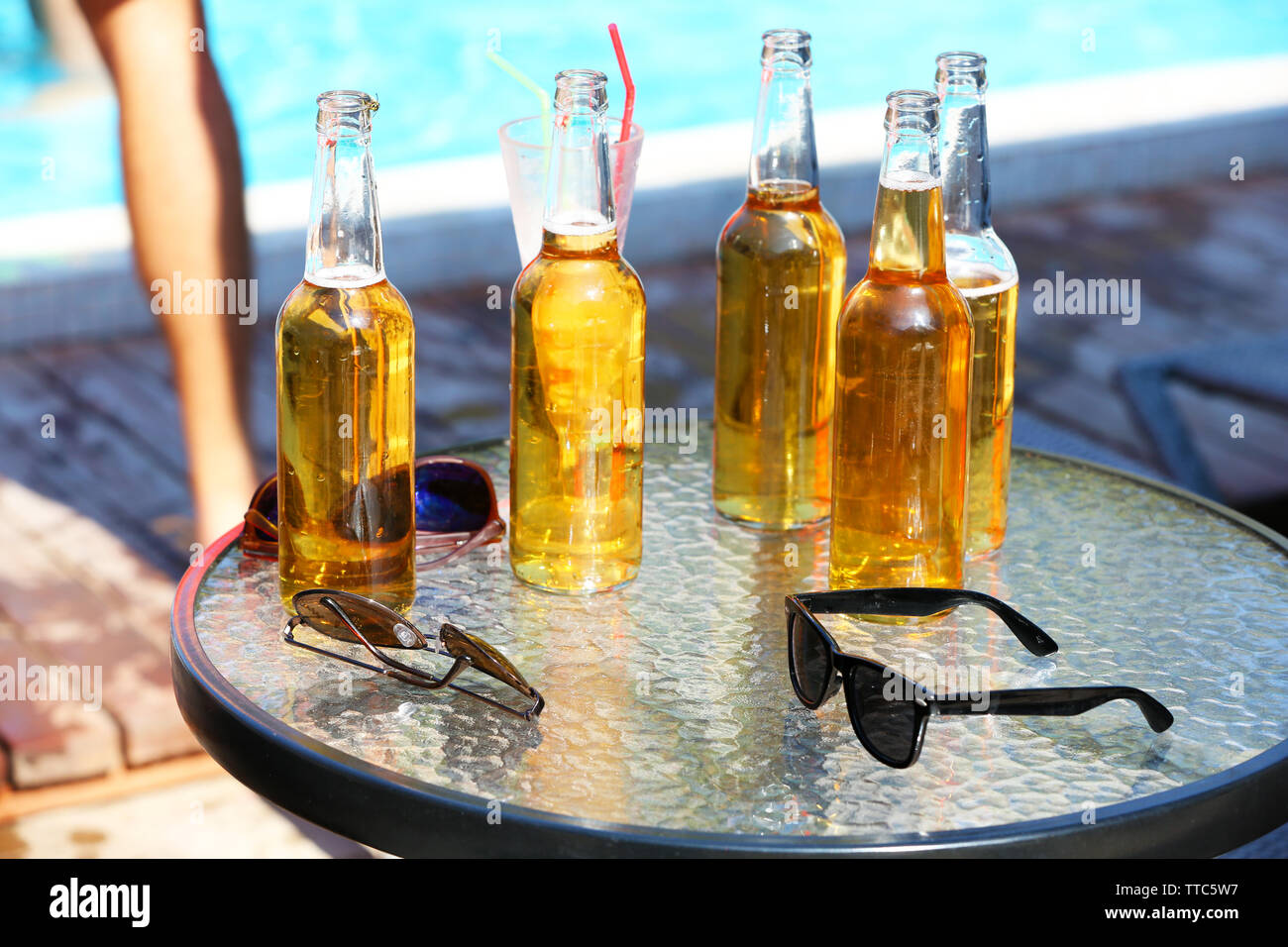 Cold beer bottles on table near swimming pool Stock Photo - Alamy