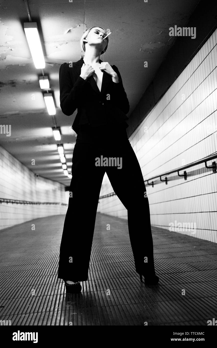 Blonde woman in black suit in a subway Stock Photo - Alamy