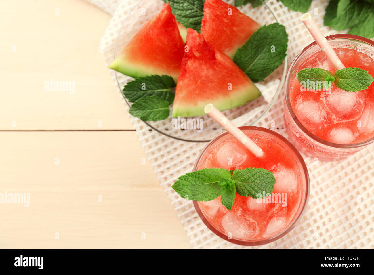 Cold watermelon desserts and drinks in glasses, on wooden table ...