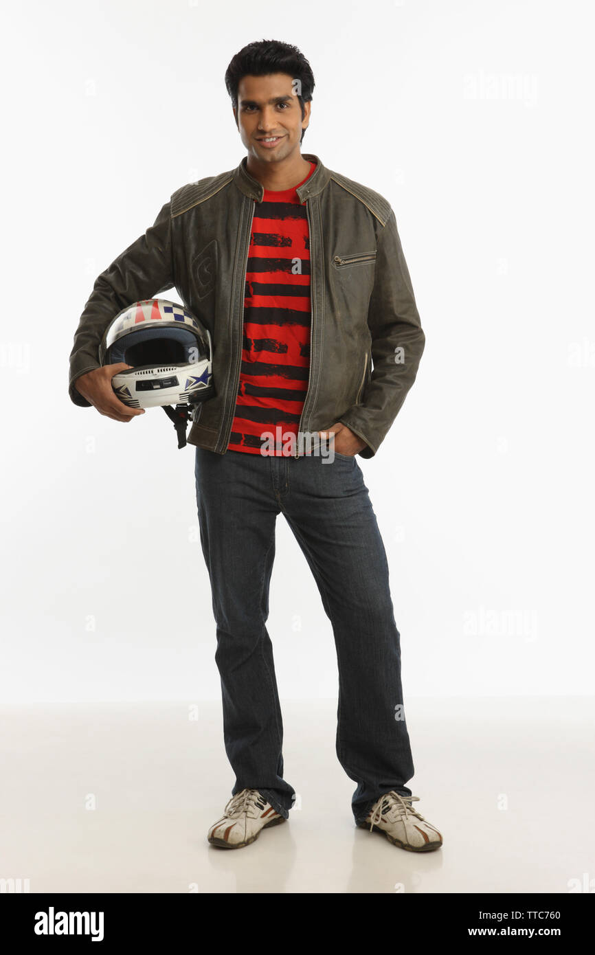 Biker holding a helmet under the arm and smiling Stock Photo - Alamy