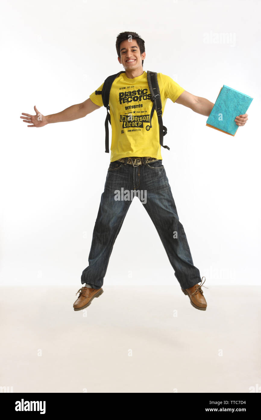 College student jumping and smiling Stock Photo - Alamy