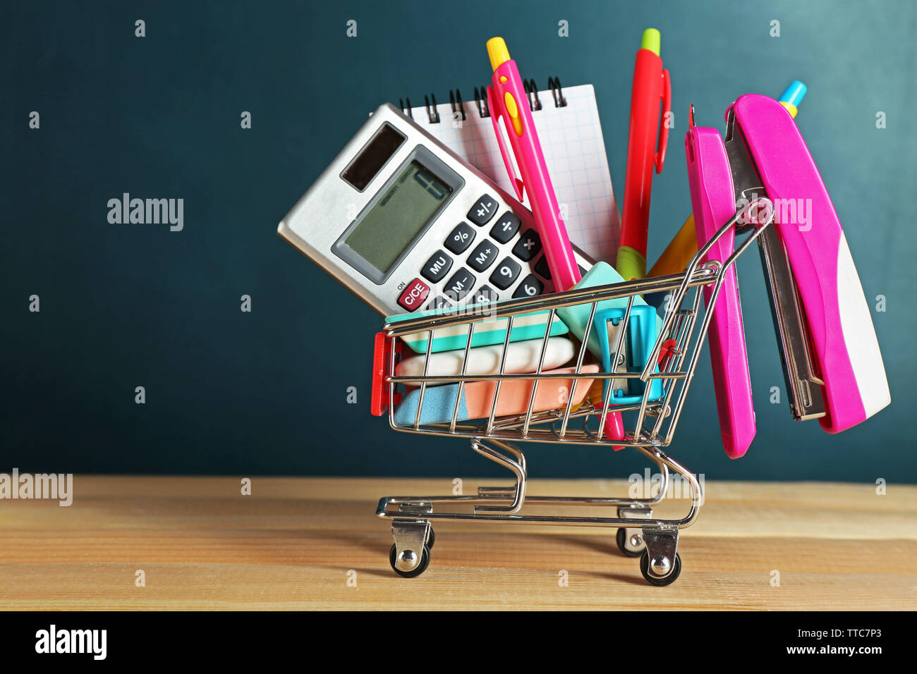 Bright stationery objects in mini supermarket cart on chalkboard ...