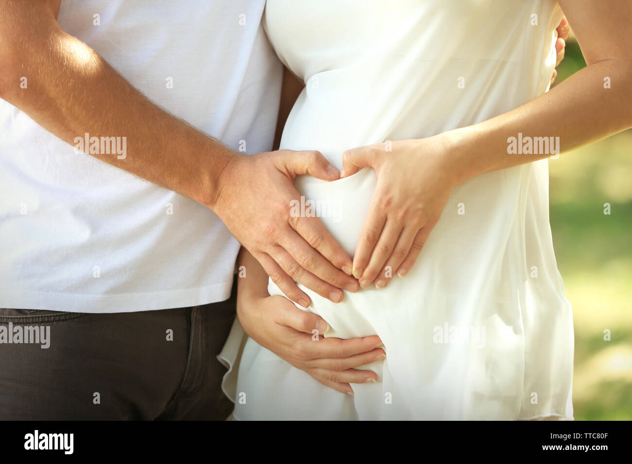 Together in waiting of baby's birth - happy man and woman in the park ...