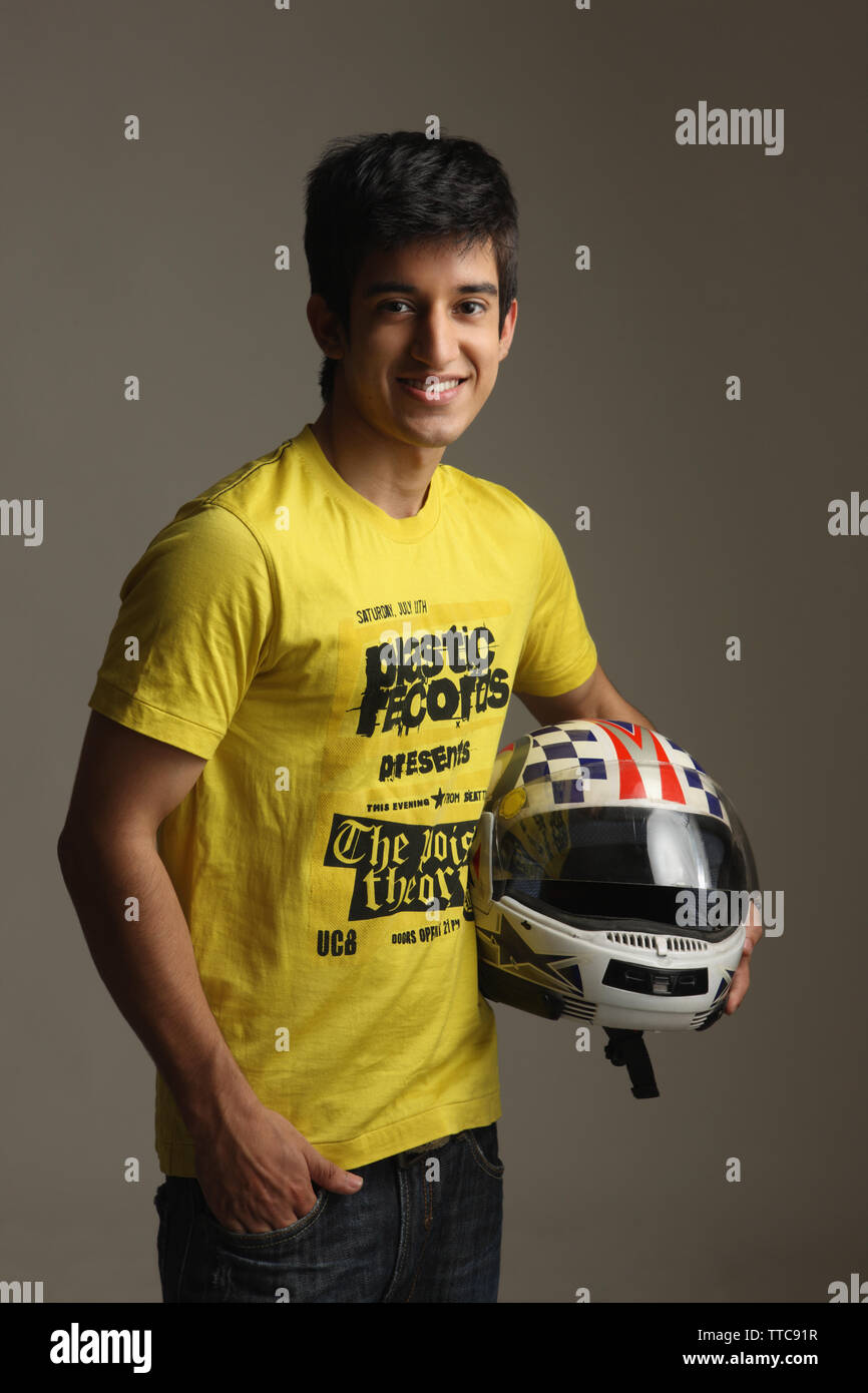 Biker holding a helmet under the arm and smiling Stock Photo - Alamy