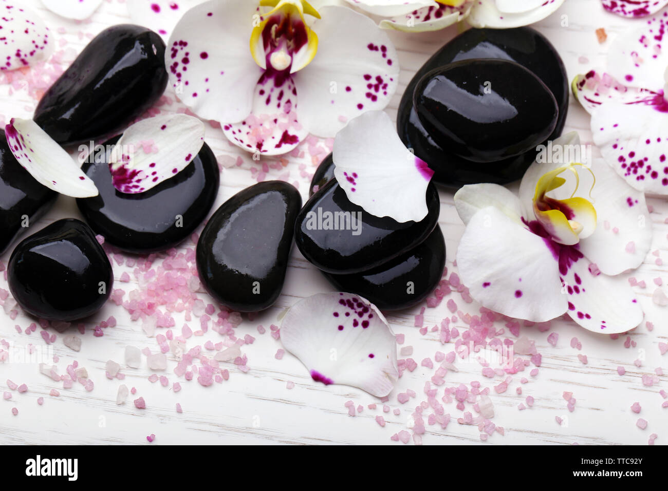 Orchid and zen stones on wooden background close-up Stock Photo - Alamy