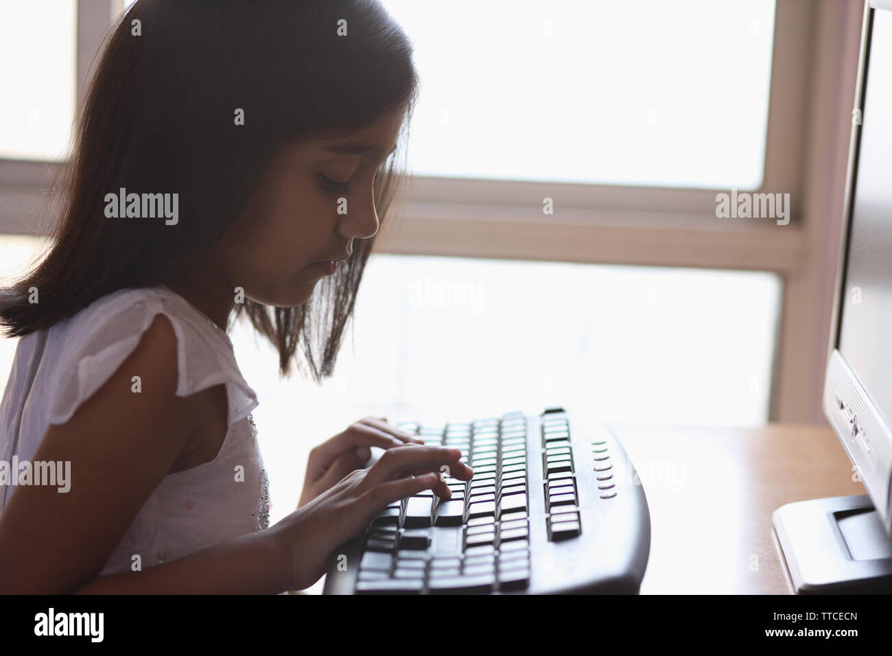 Side profile of a girl working on a computer Stock Photo - Alamy