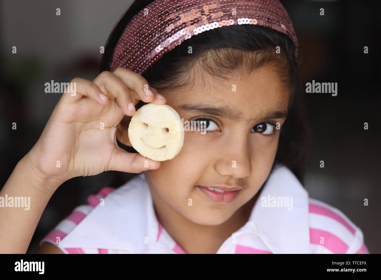 Portrait of a girl showing smiley face potato patty Stock Photo - Alamy