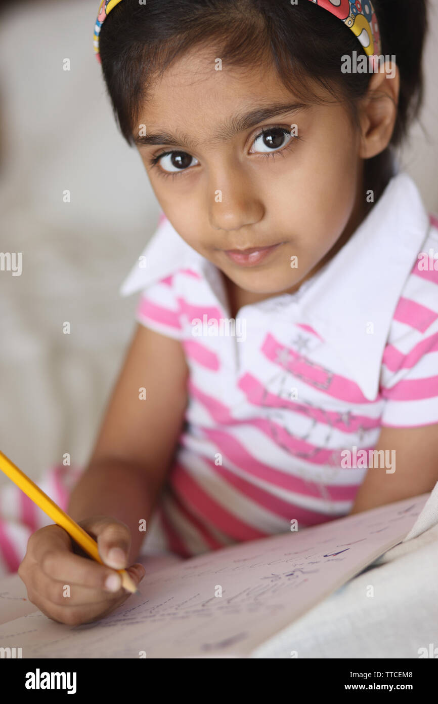 Girl writing in a workbook Stock Photo - Alamy