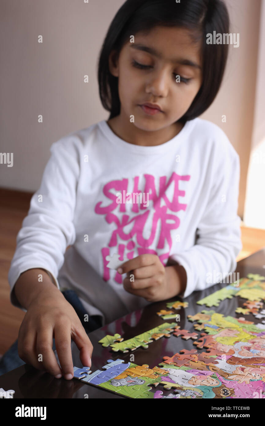 Girl playing with jigsaw puzzle Stock Photo - Alamy