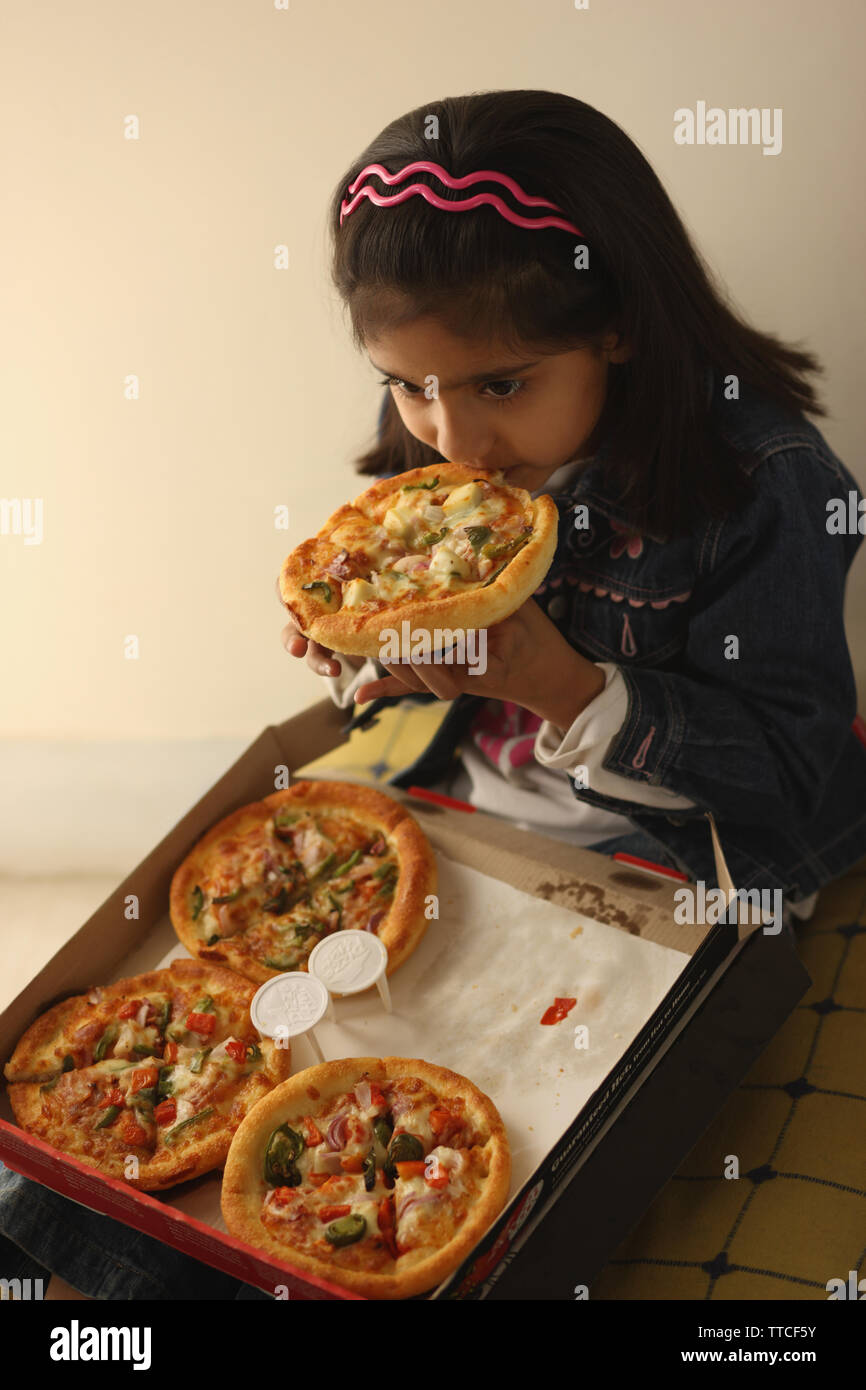 Girl eating pizza Stock Photo - Alamy