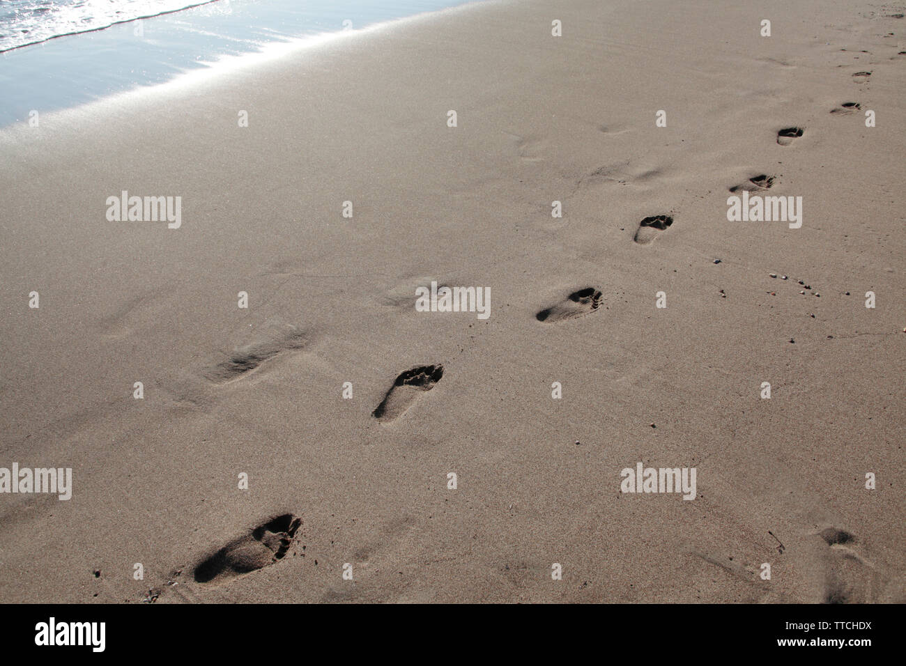 Footsteps on the sand Stock Photo - Alamy