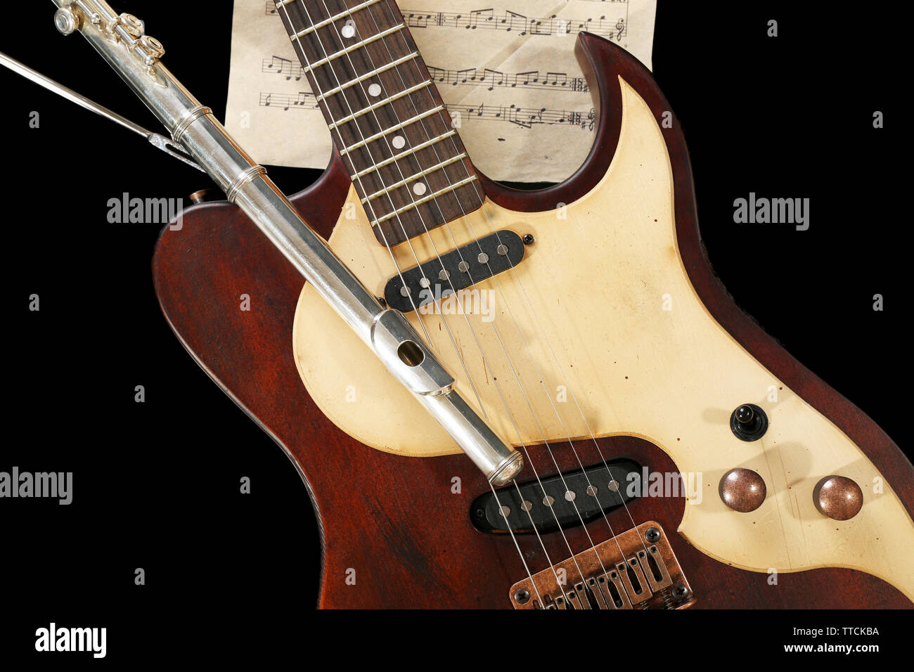 Flute, electric guitar and note sheets on black background Stock Photo ...