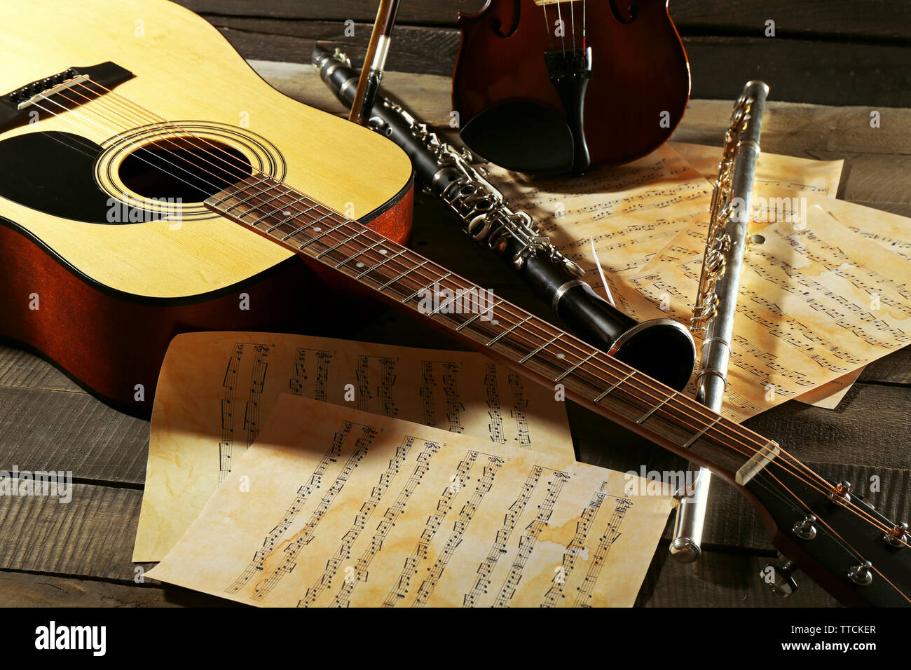 Acoustic guitar, soprano saxophone, violin, flute and note sheets on ...