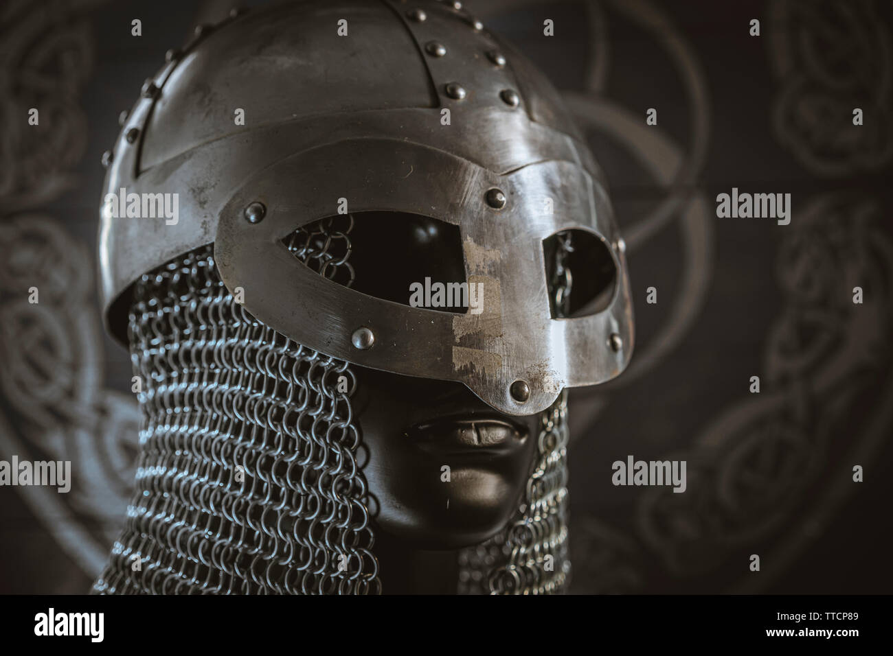 Viking helmet with chain mail of iron on red shield of wood and golden ...