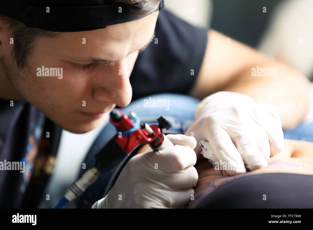 Tattooist makes tattoo, close up Stock Photo - Alamy