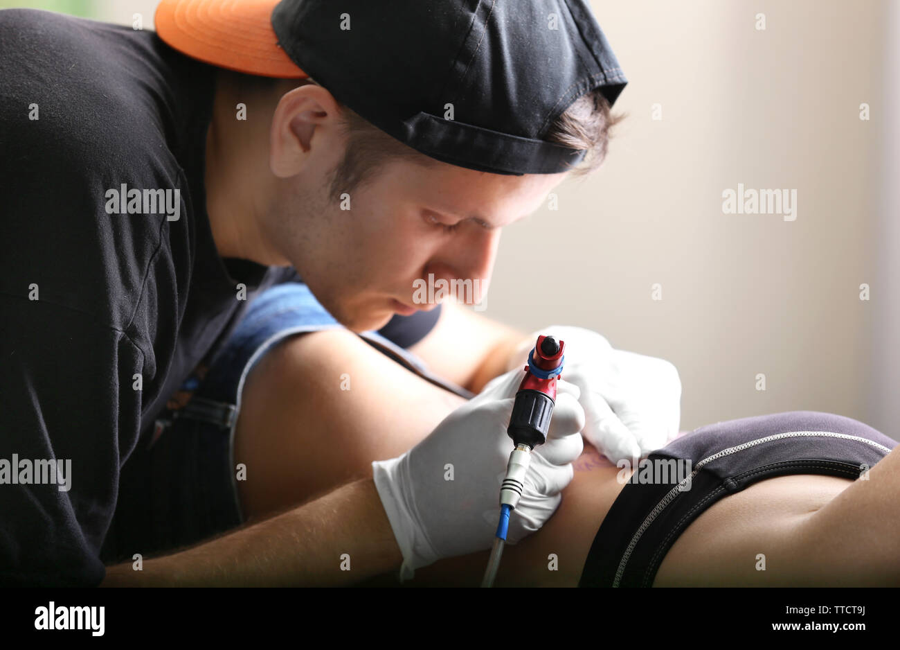 Tattooist makes tattoo, close up Stock Photo - Alamy