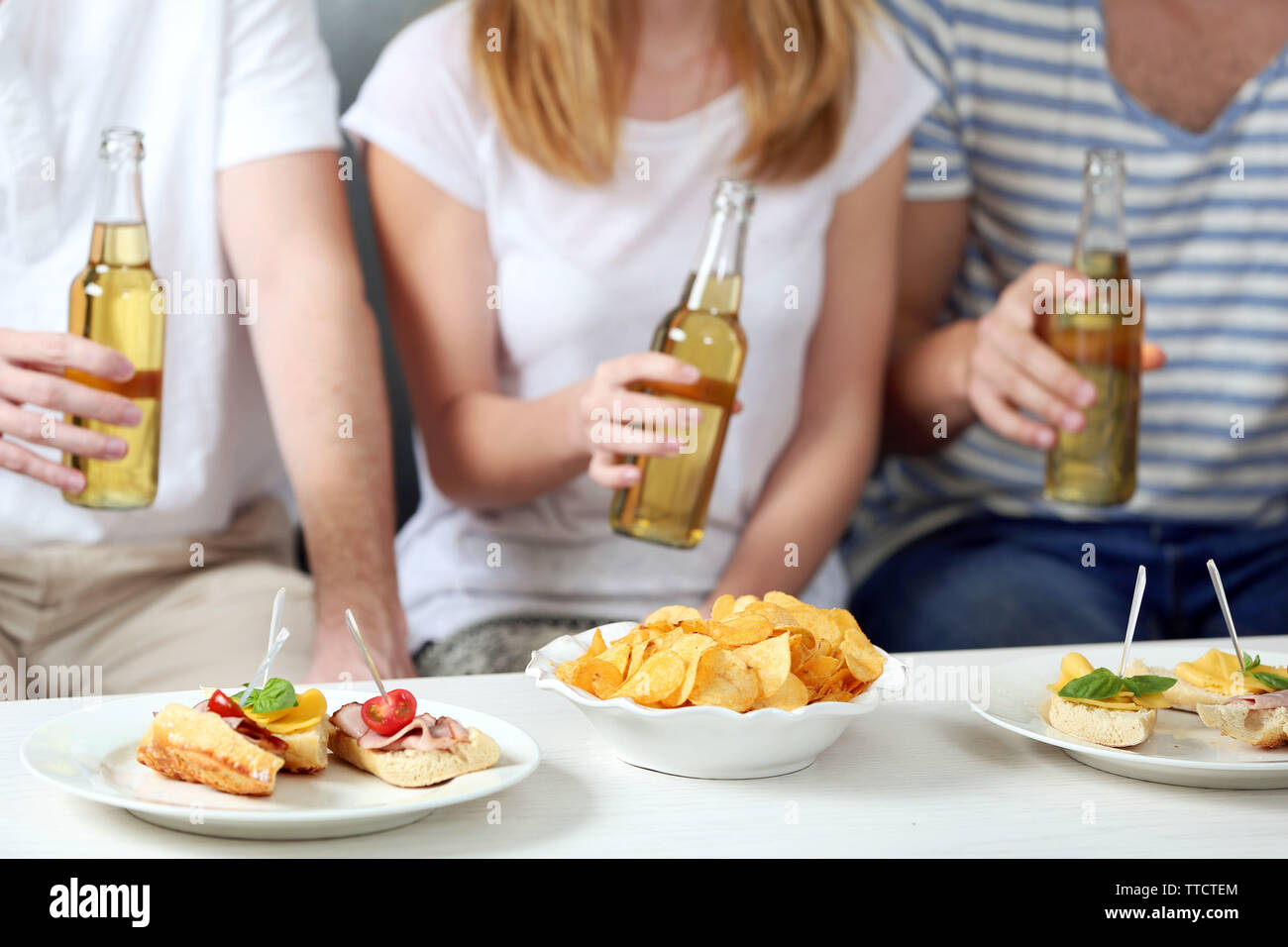 Friends hands with bottles of beer and snacks , close up Stock Photo ...