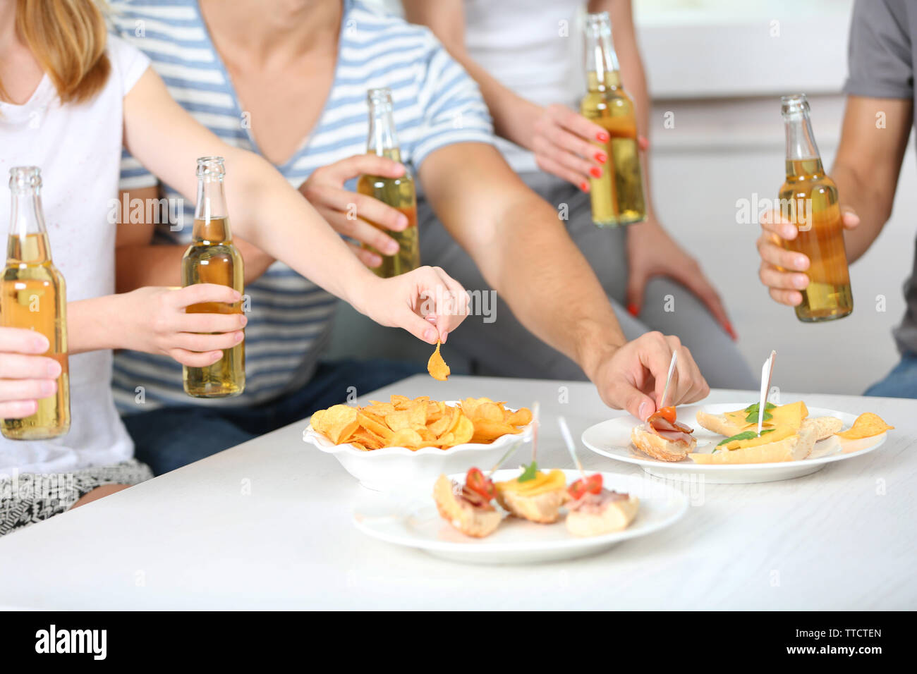 Friends hands with bottles of beer and snacks , close up Stock Photo ...