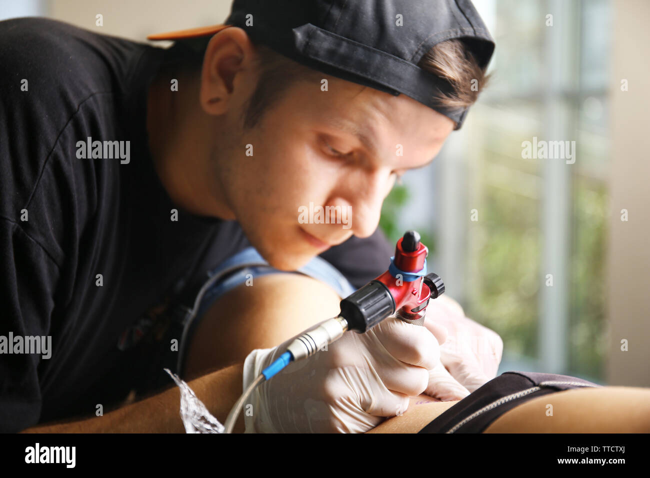 Tattooist makes tattoo, close up Stock Photo - Alamy