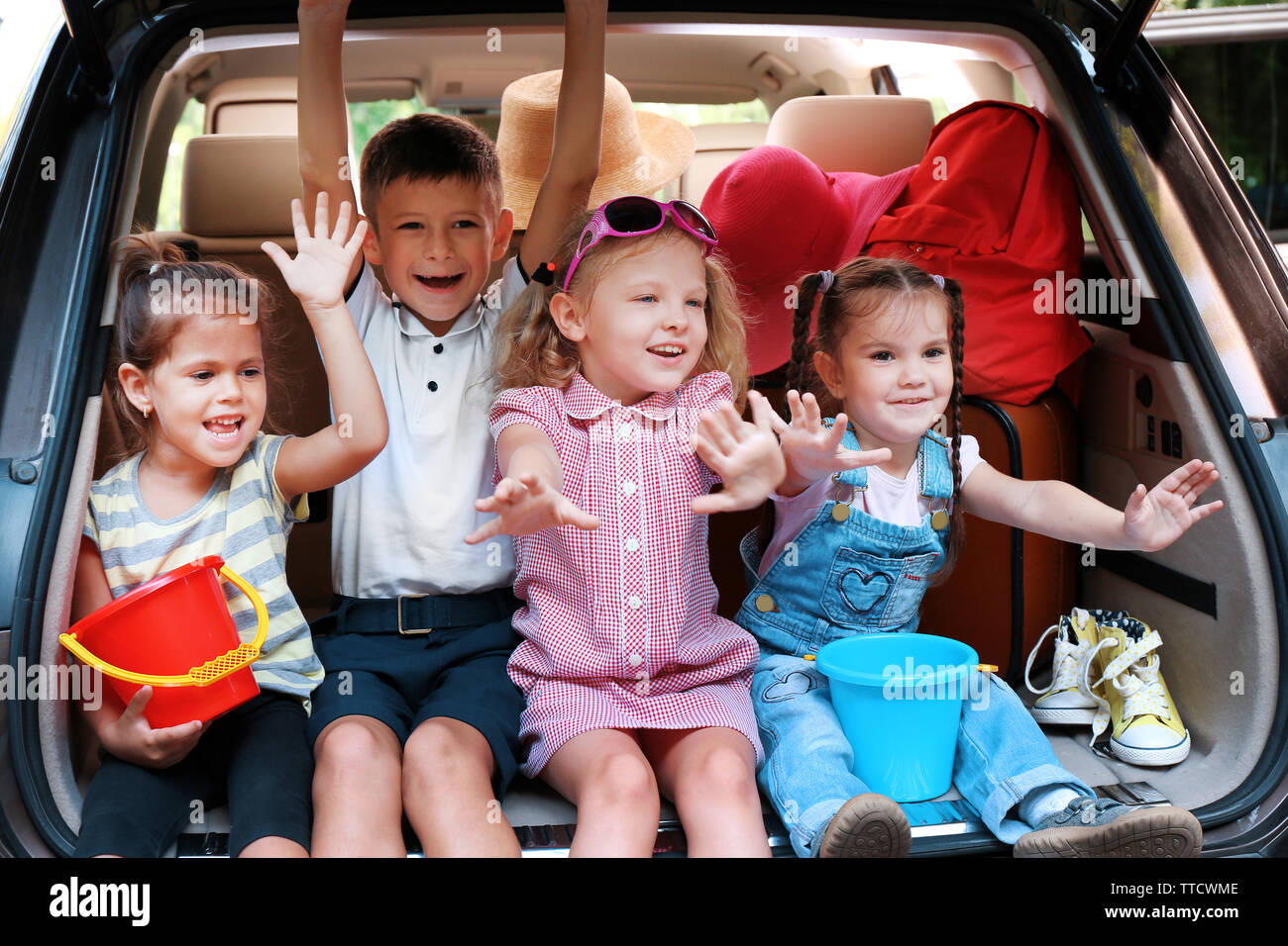 Happy children sit on a car trunk and laughing Stock Photo - Alamy