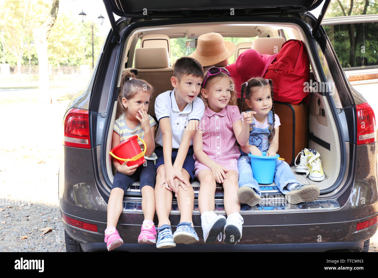 Happy children sit on a car trunk and laughing Stock Photo - Alamy