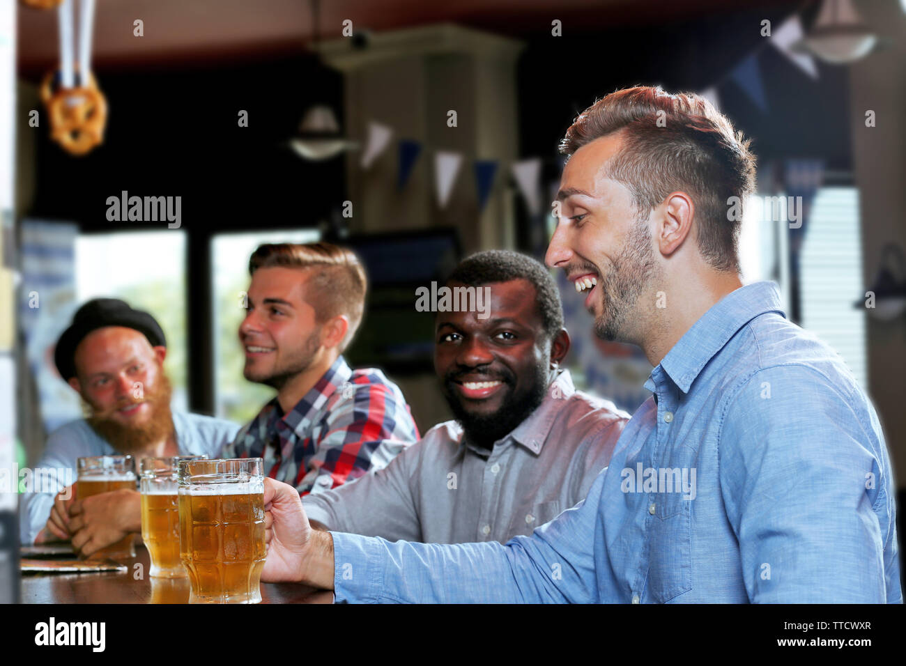 Young men drinking beer in pub Stock Photo - Alamy