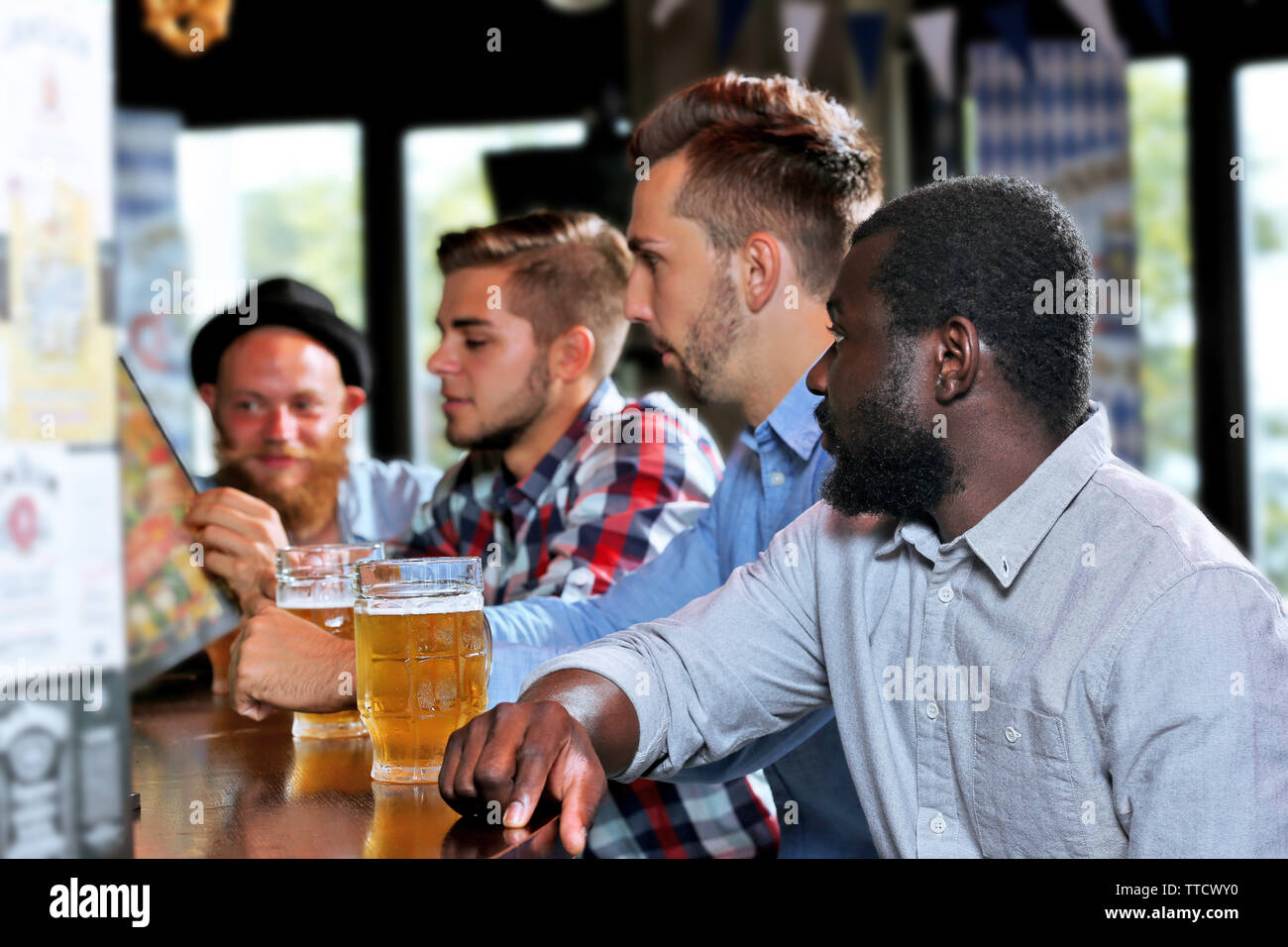 Young men drinking beer in pub Stock Photo - Alamy