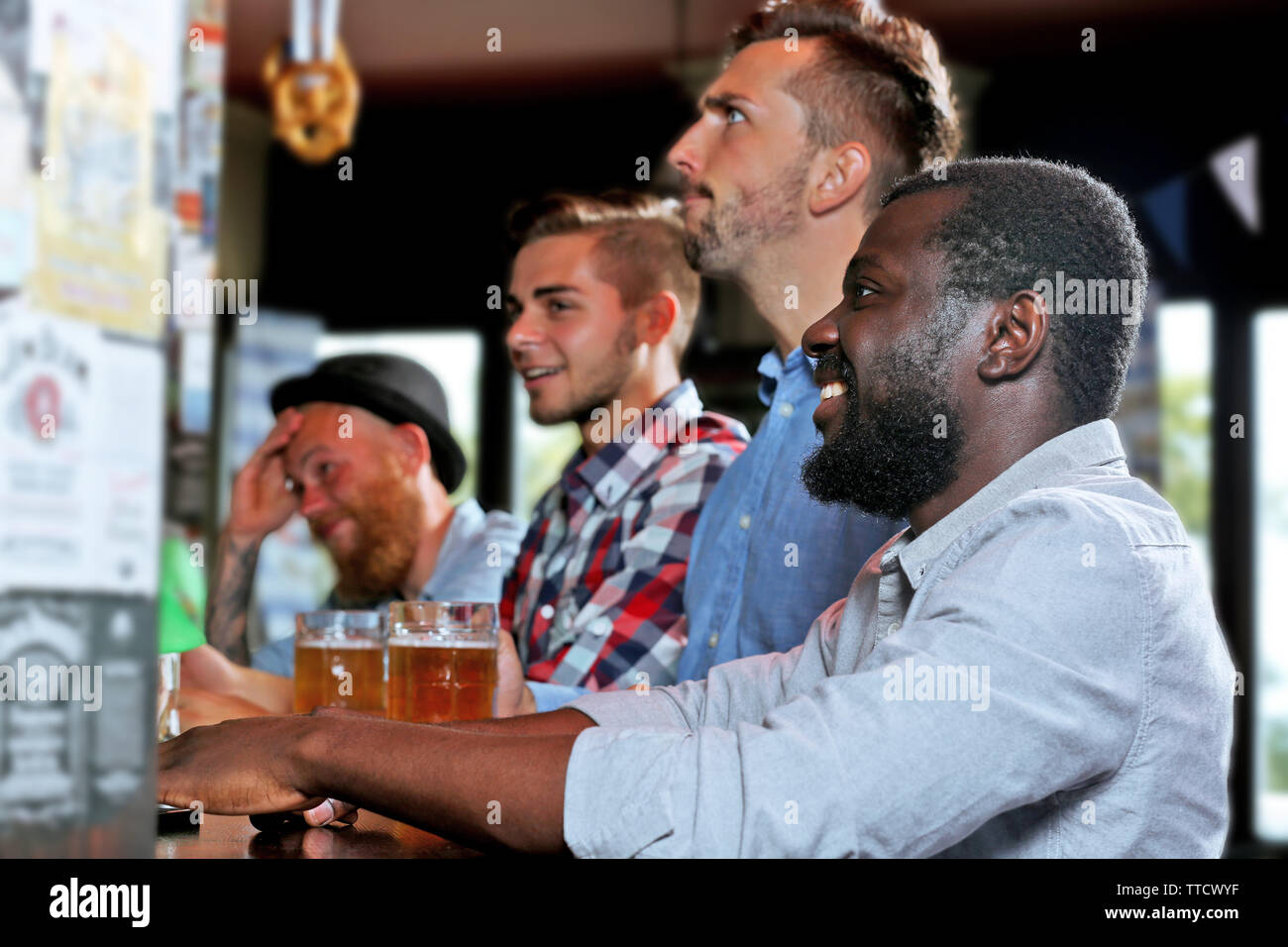 Young men drinking beer in pub Stock Photo - Alamy