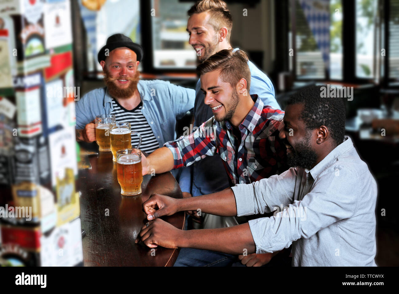 Young men drinking beer in pub Stock Photo - Alamy