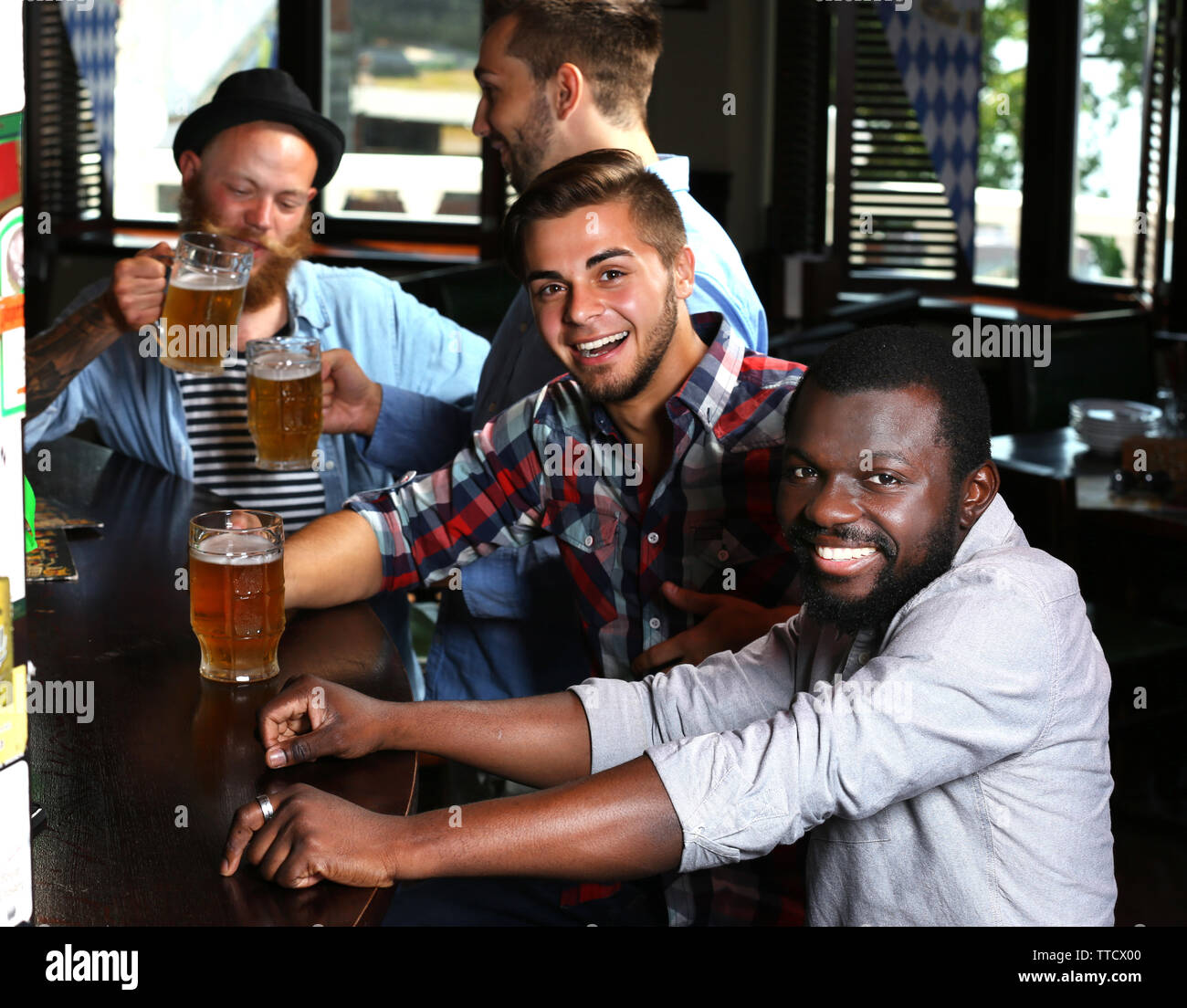 Young men drinking beer in pub Stock Photo - Alamy
