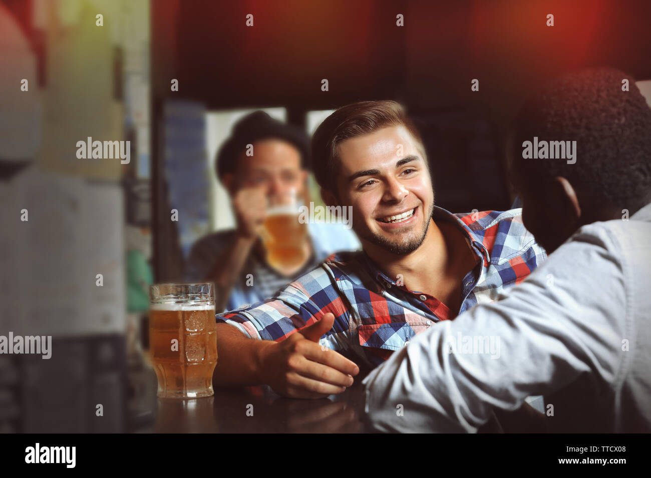 Young men drinking beer in pub Stock Photo - Alamy