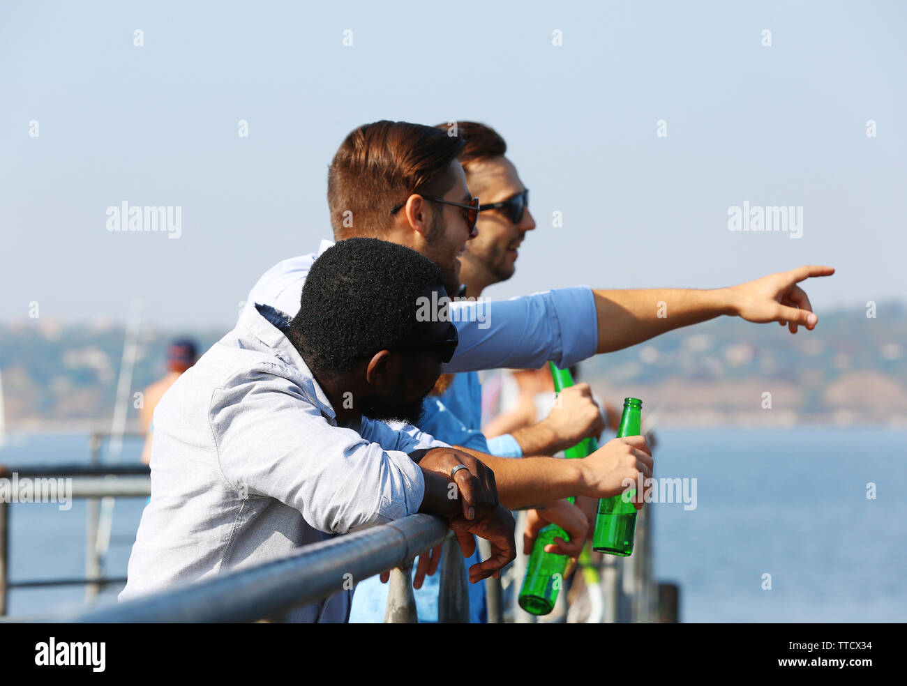 Young men talking on the riverside Stock Photo - Alamy