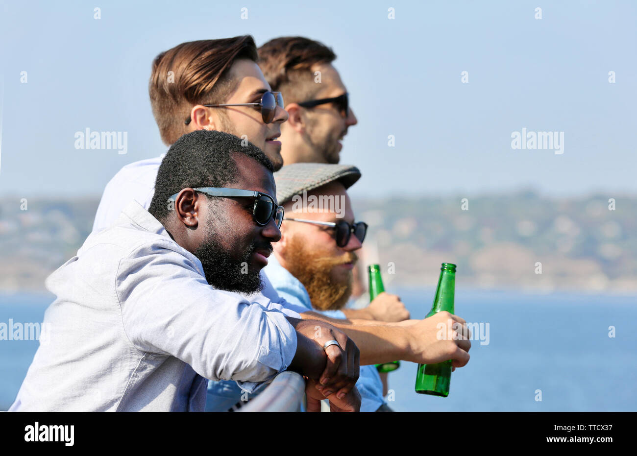 Young men talking on the riverside Stock Photo - Alamy