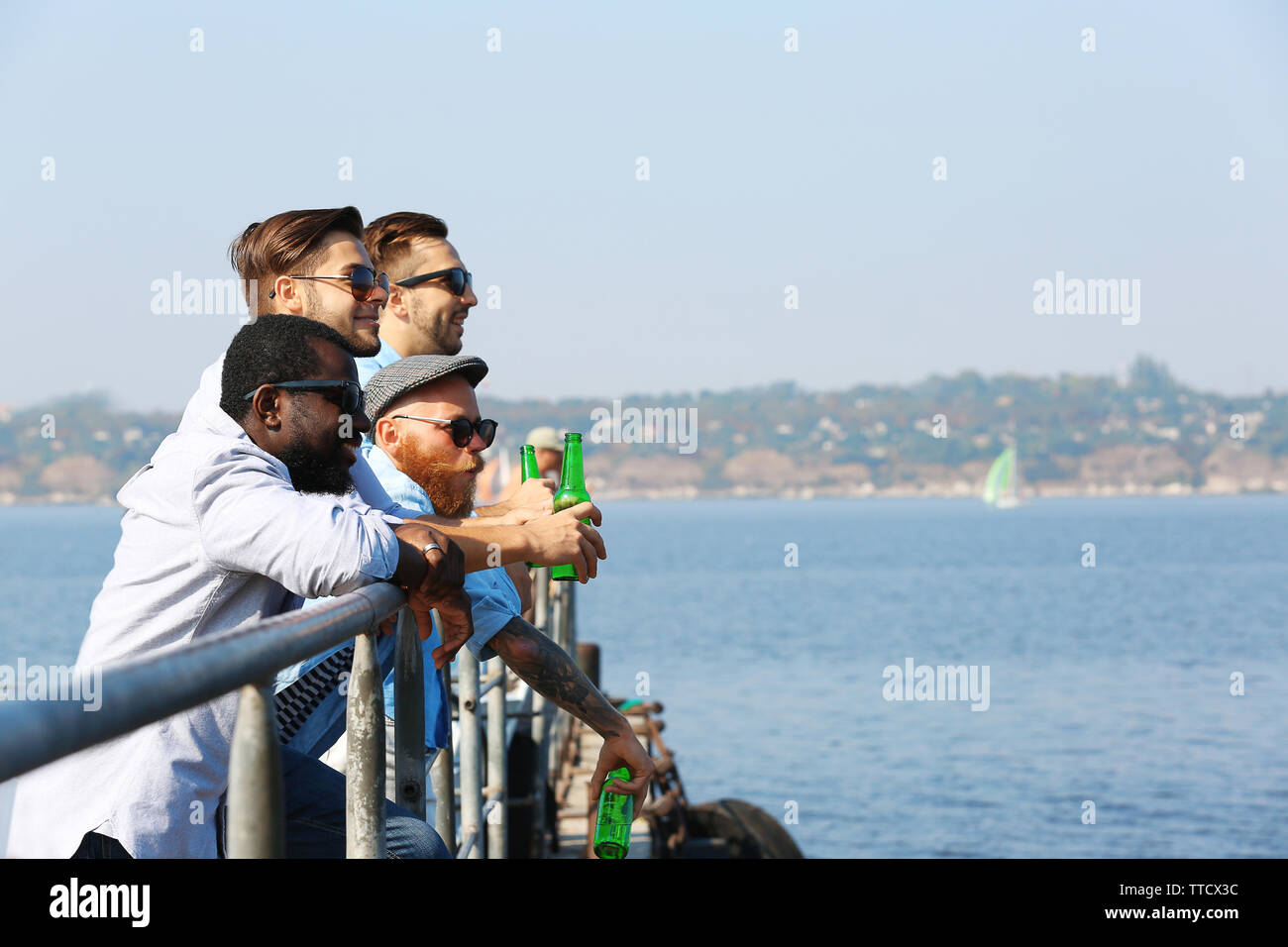 Young men talking on the riverside Stock Photo - Alamy