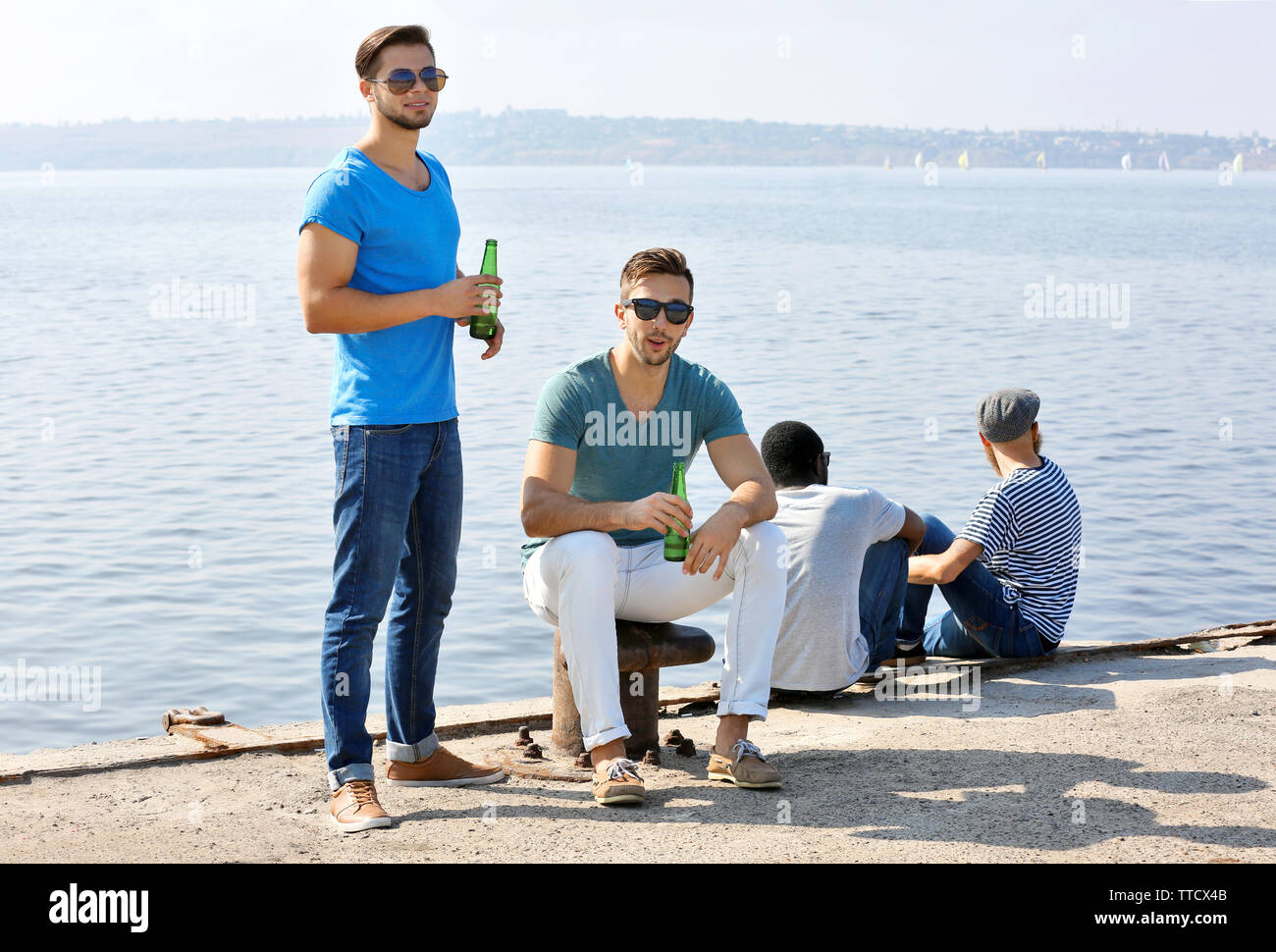 Young men talking on the riverside Stock Photo - Alamy