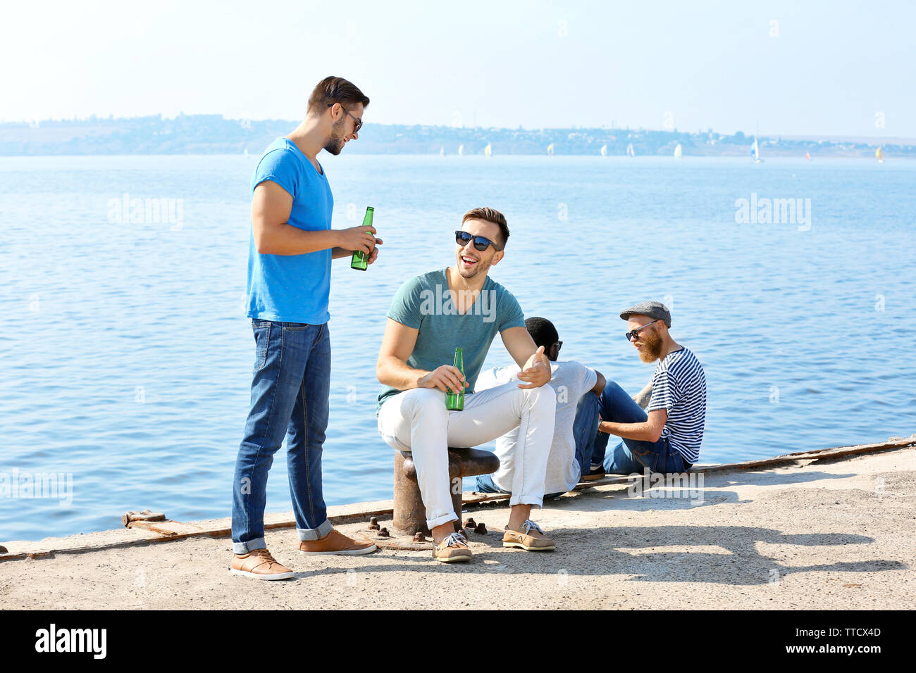 Young men talking on the riverside Stock Photo - Alamy