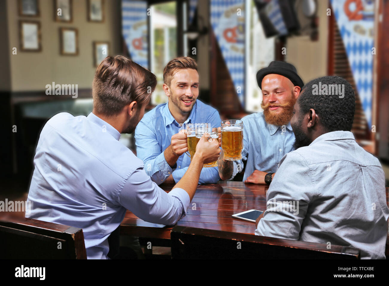 Young men drinking beer and talking in cafe Stock Photo - Alamy