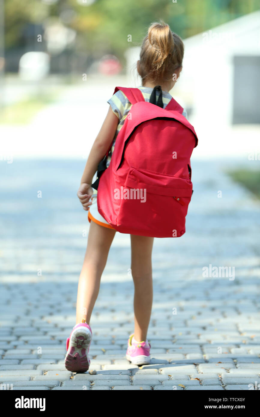 Little girl with large school bag, outdoor Stock Photo - Alamy