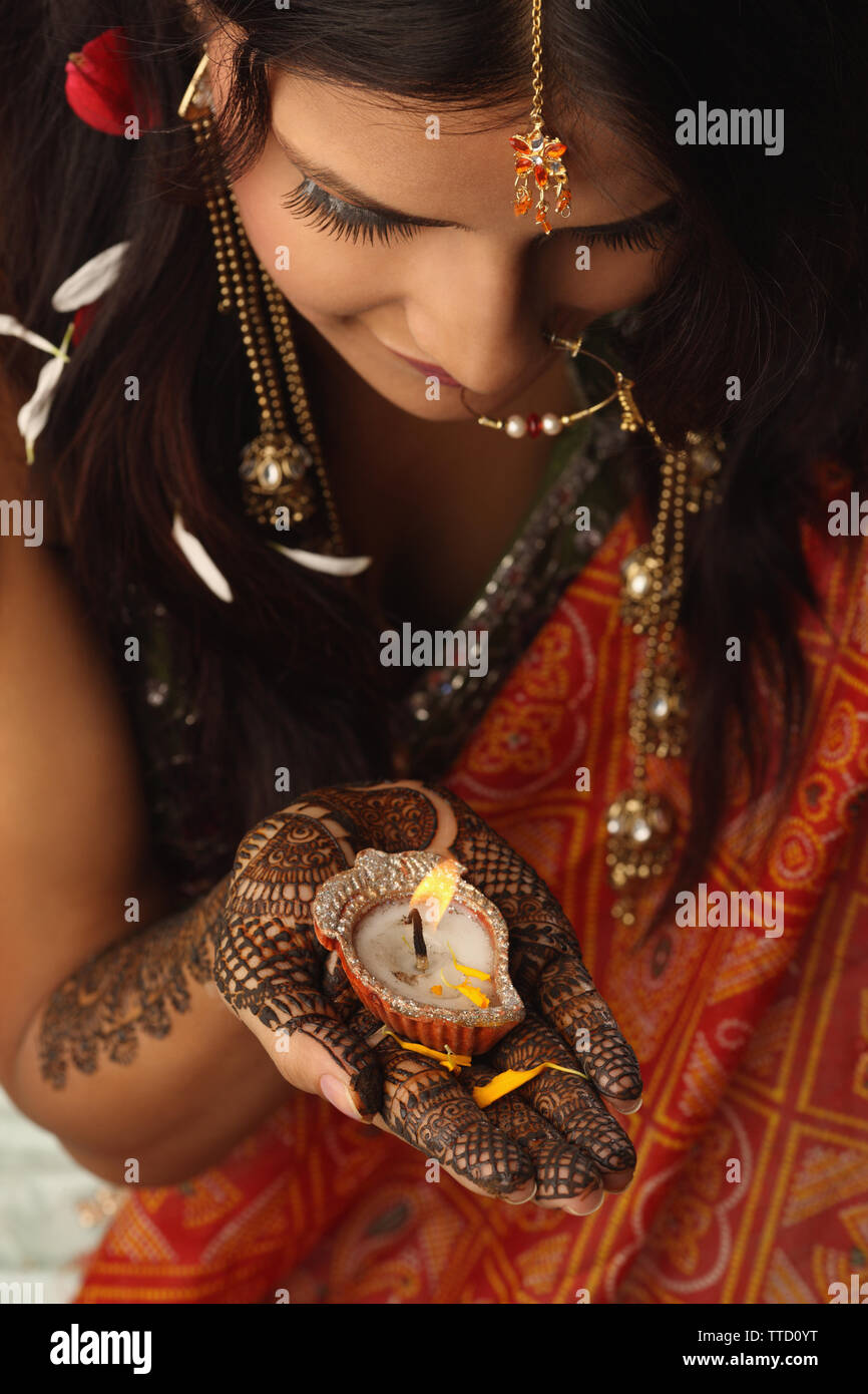 Indian bride holding a diya on her palm Stock Photo - Alamy