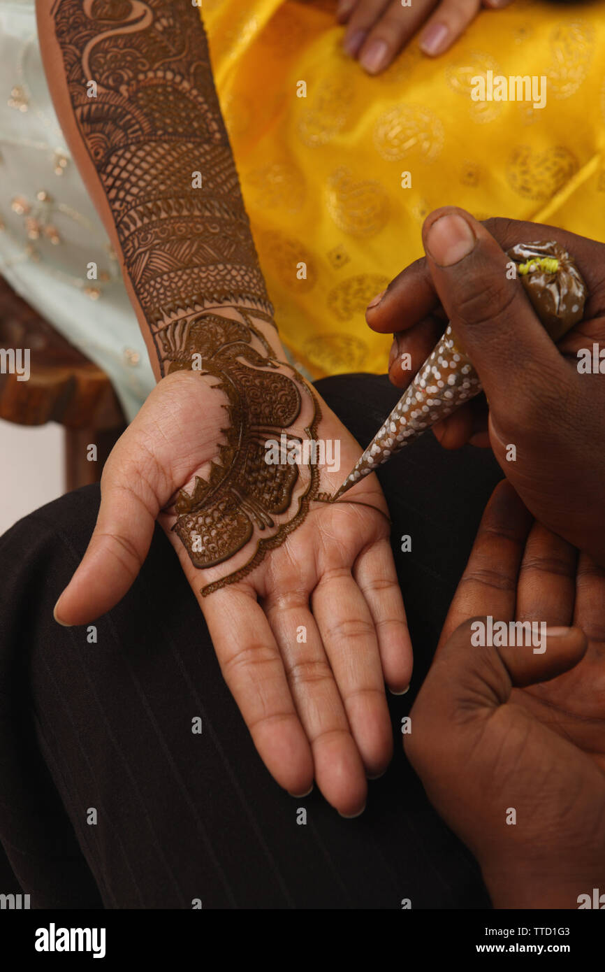 Artist hand applying mehendi on a bridal arm Stock Photo - Alamy