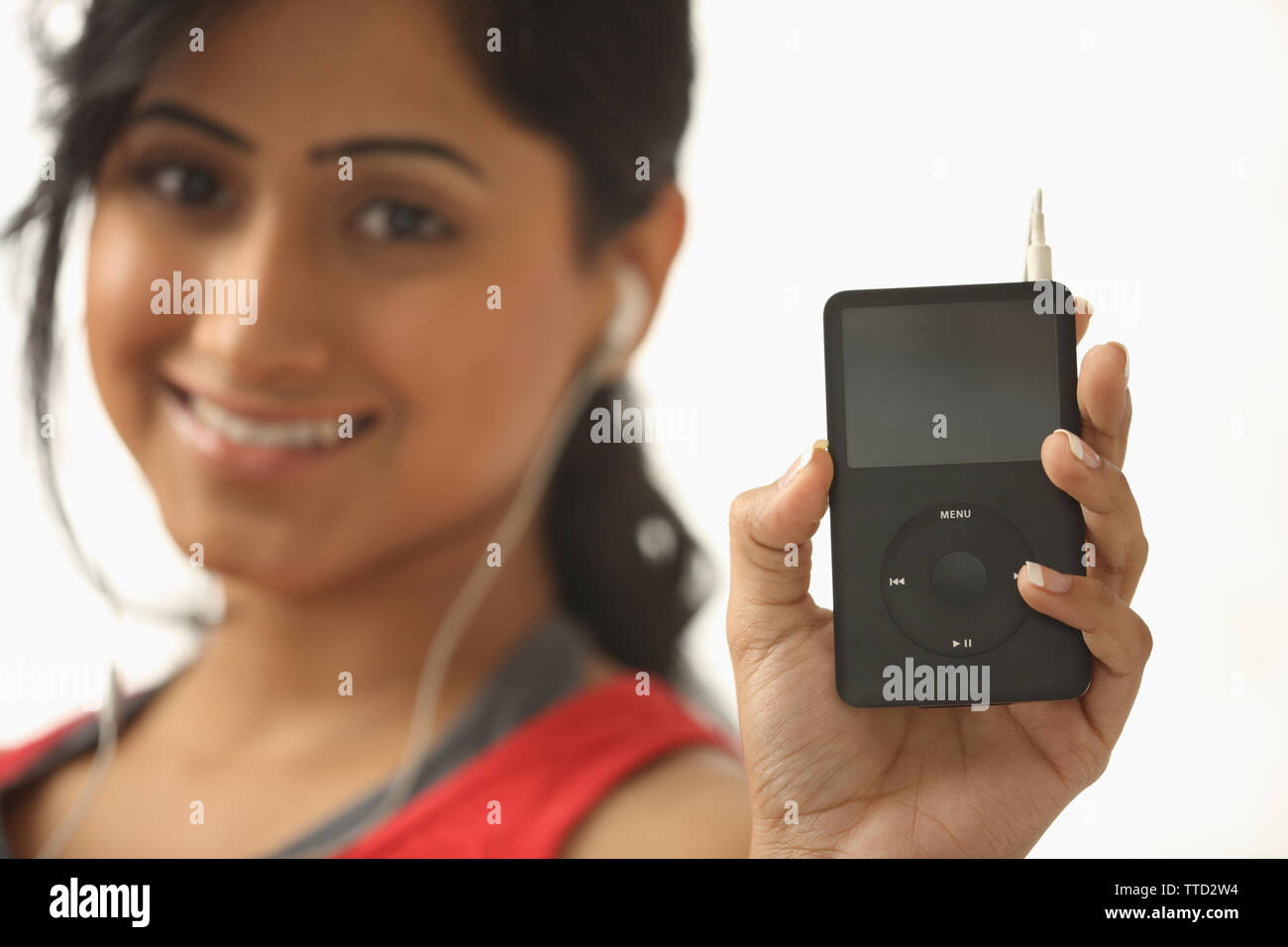 Woman showing MP3 player and smiling Stock Photo - Alamy