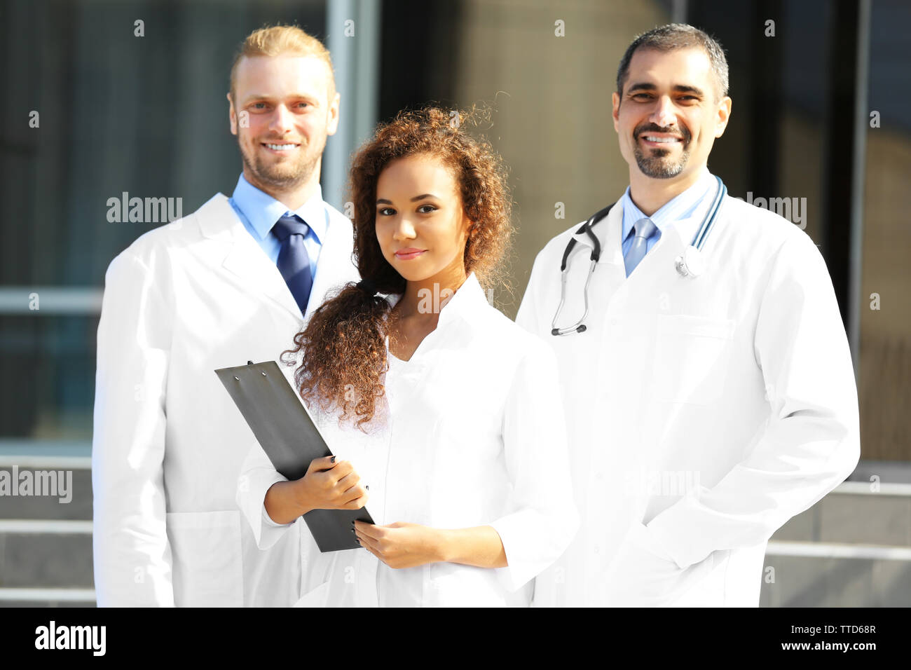 Smart young doctors team standing against hospital entrance Stock Photo ...