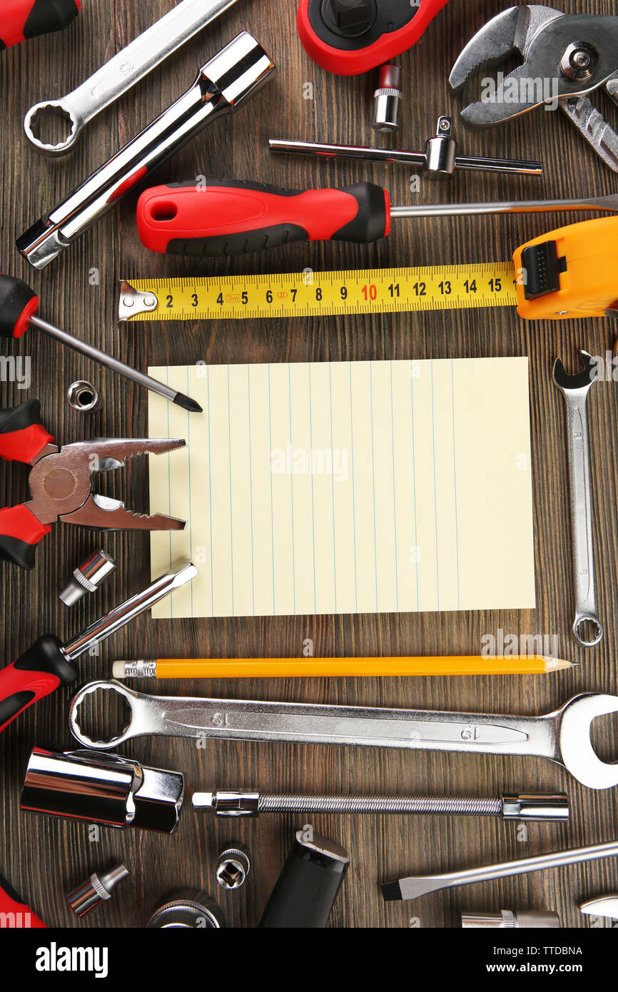 Different kinds of tools with a notebook on wooden background Stock ...