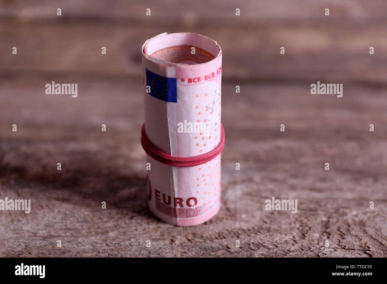 Roll of Euro banknotes on wooden background Stock Photo - Alamy