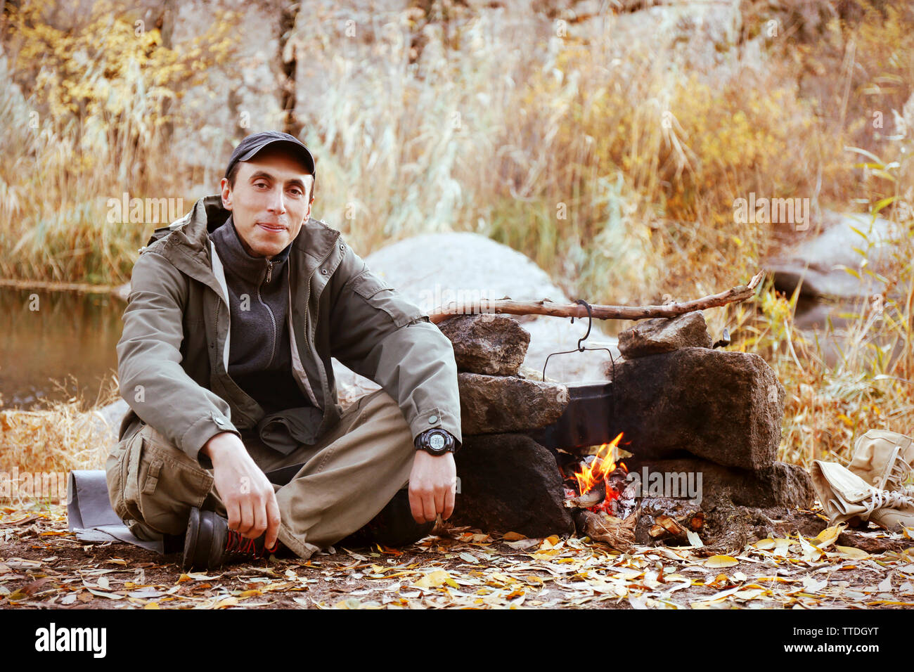 Man sitting beside fireplace outdoor Stock Photo - Alamy