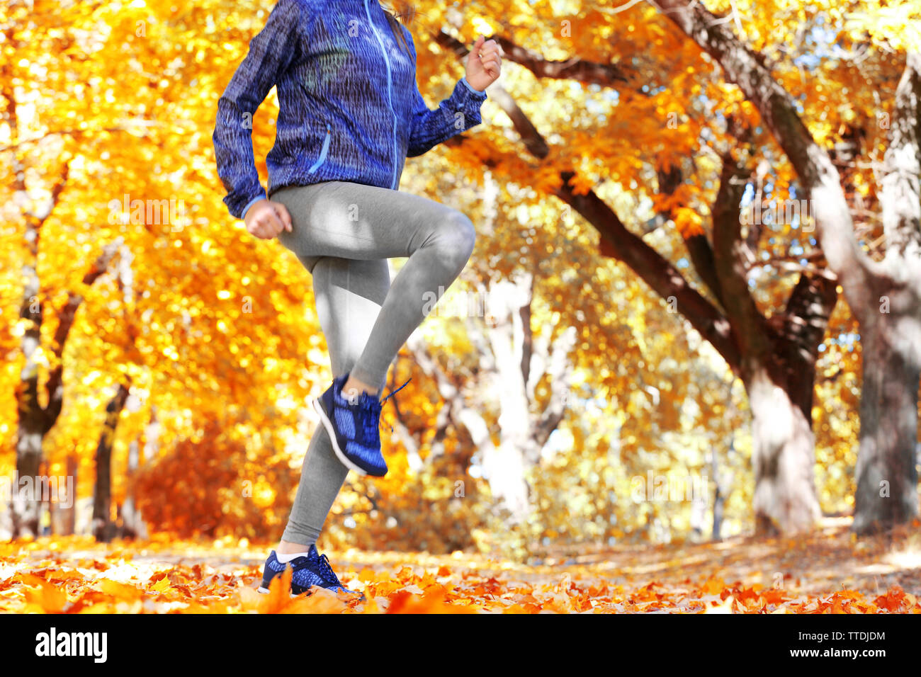 Young woman jogging in autumn park Stock Photo - Alamy