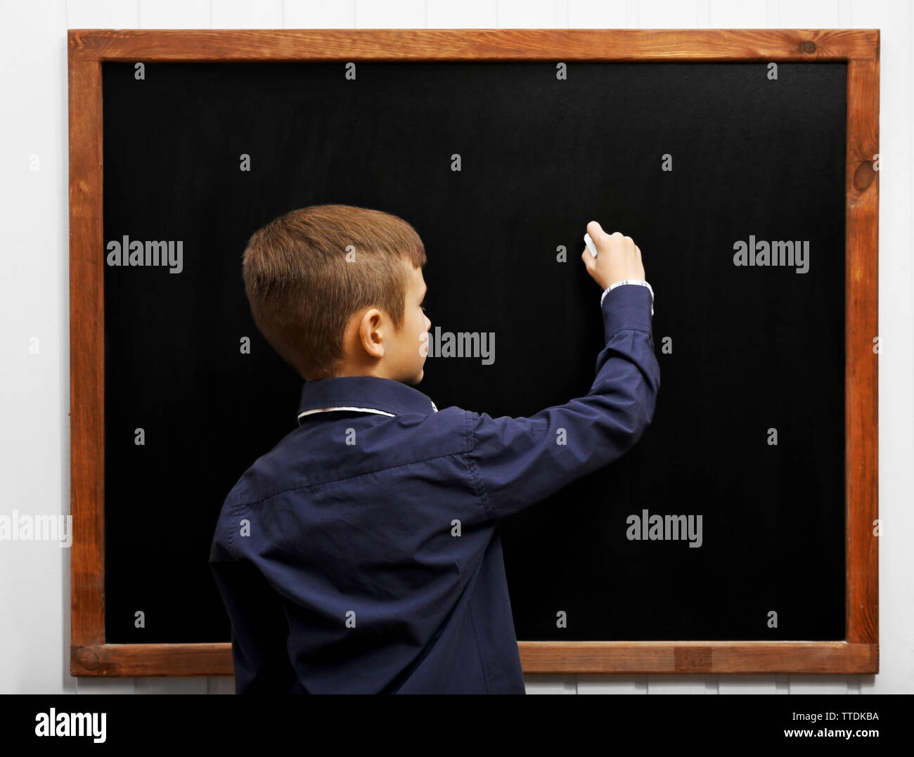 Back view of a boy posing at the blackboard, in the classroom Stock ...